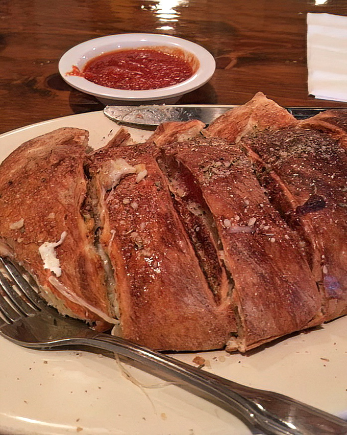 A calzone that's achieved that perfect golden-brown exterior while hiding a treasure trove of melted cheese and fillings inside. Food architecture at its finest.