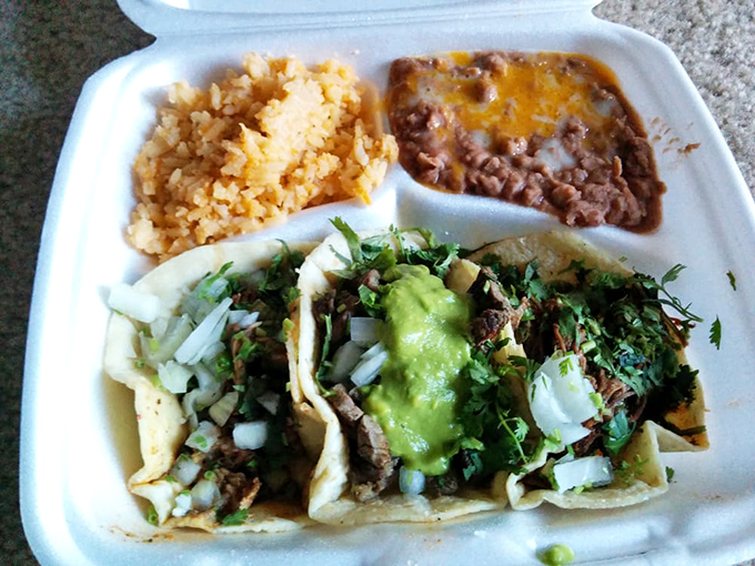 Carne asada tacos served with the holy trinity of Mexican sides—fluffy rice, creamy beans, and enough cilantro and onion to make everything sing.