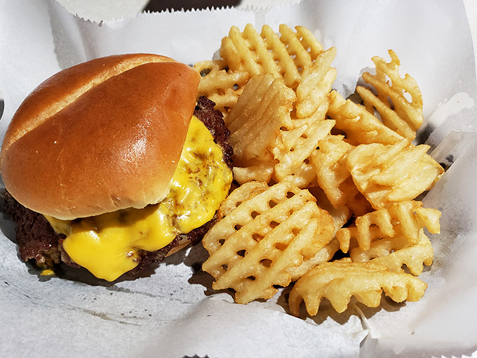 A proper burger and waffle fries&mdash;the kind of honest-to-goodness plate that reminds you why simple food done right beats fancy cuisine any day.