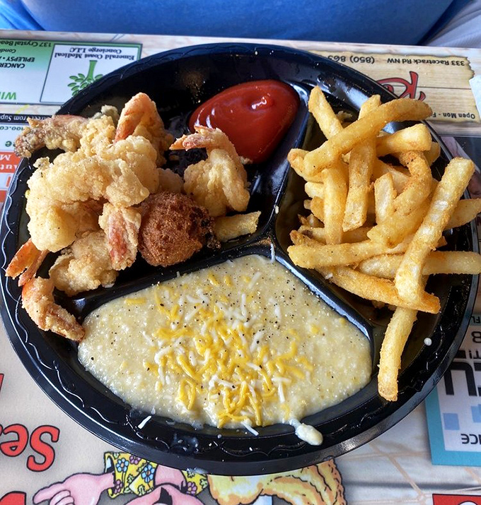 The holy trinity of Gulf Coast comfort: fried shrimp, seasoned fries, and cheese grits that flow like edible gold. Compartment plates never contained such treasure.