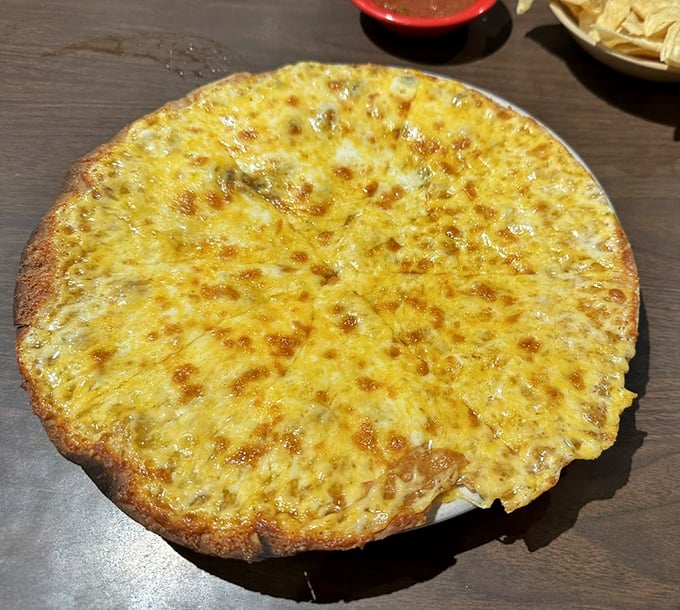 This golden cheese crisp stretches wider than your wingspan, bubbling with melted cheese that could make grown adults weep joyfully.