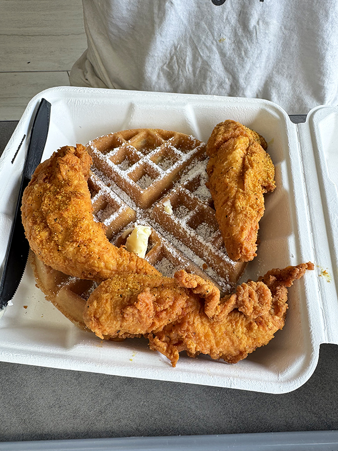 The holy trinity of comfort food: golden fried chicken, a powdered sugar-dusted waffle, and that little pat of butter slowly melting into breakfast-dinner paradise.