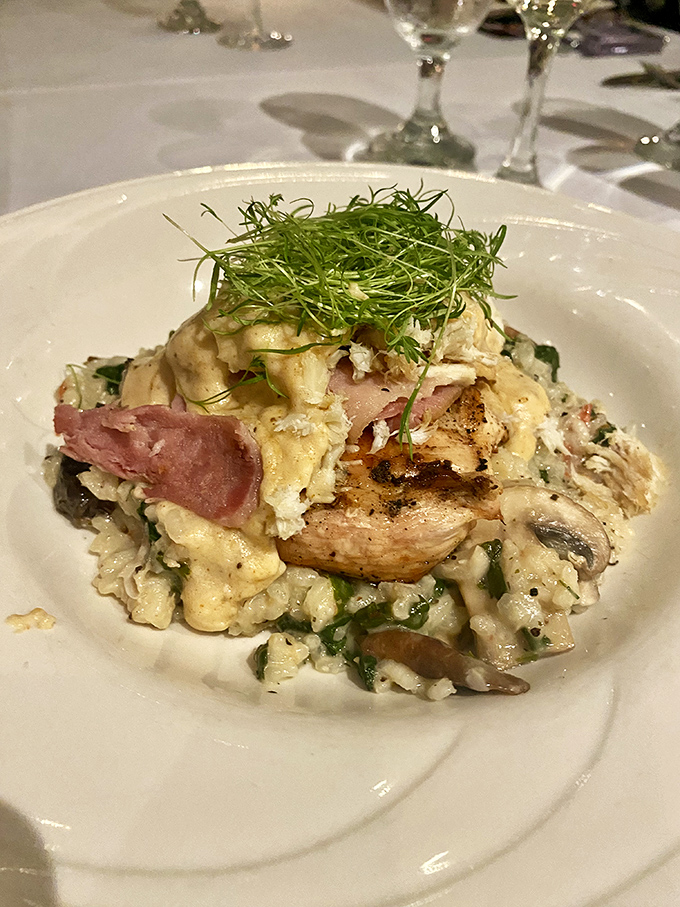 This risotto dish is like a culinary United Nations, where chicken, ham, and seafood negotiate deliciously under a canopy of fresh microgreens.