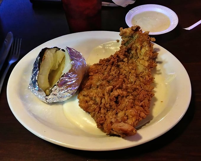 Chicken fried steak so perfectly breaded it makes Southern grandmothers nod in approval. The baked potato stands by, waiting its turn.