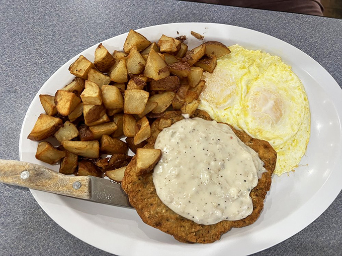 Chicken fried steak getting the gravy treatment it deserves, alongside eggs sunny enough to brighten even Monday mornings.