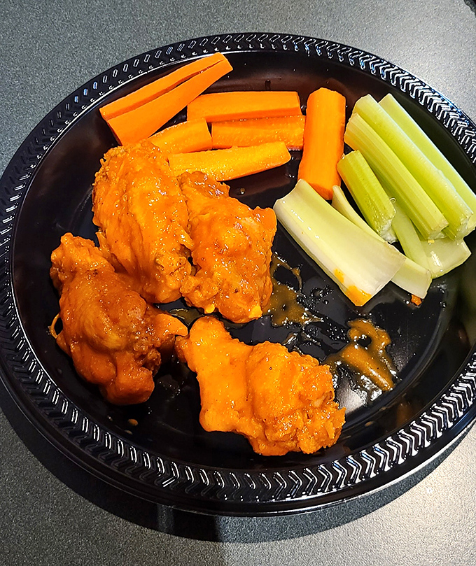 These buffalo wings aren't just orange&mdash;they're practically glowing with flavor potential, standing at attention next to their cooling vegetable companions.