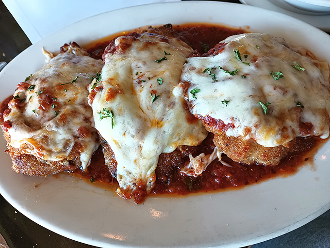 The star of the show: chicken parmesan with cheese that stretches toward heaven and a crispy exterior that defies soggy sauce physics.