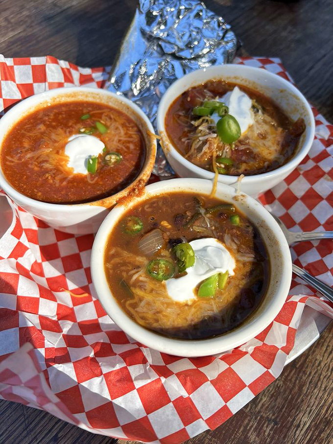 Three bowls of chili happiness, each topped with sour cream and ready to warm your very soul.