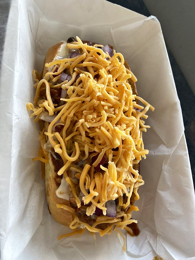 Shredded cheese cascades over this hot dog like a yellow waterfall of flavor. Whoever said "less is more" clearly never ate here.