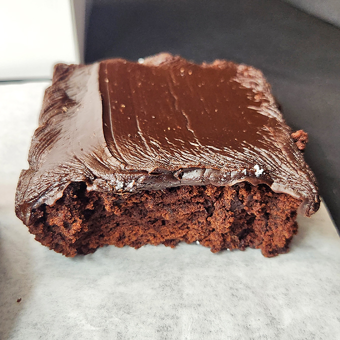Chocolate brownie perfection that would make Willy Wonka jealous. That frosting looks thick enough to swim in.
