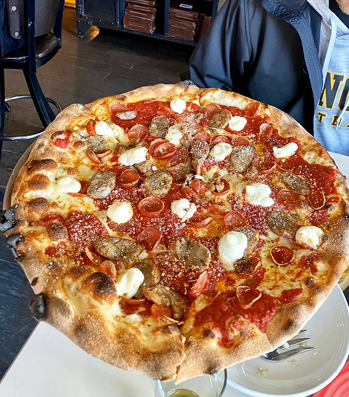 Not all heroes wear capes—some wear cheese and pepperoni. This coal-fired masterpiece with its perfect char and melty cheese spots deserves its own theme song.