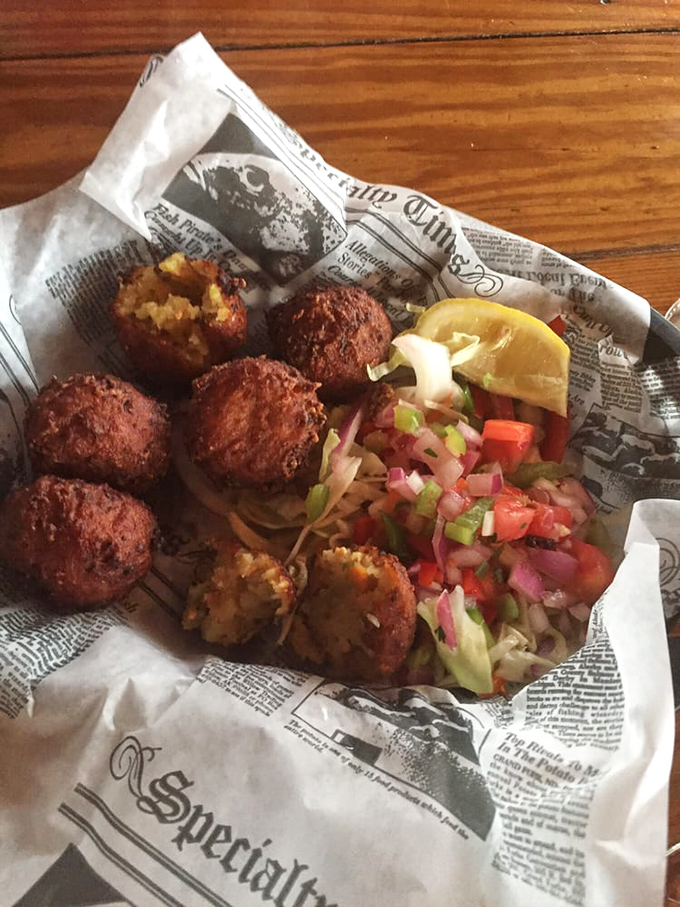 Conch fritters done right&mdash;crispy golden spheres of the sea, served with enough colorful slaw to make your Instagram followers weep with envy.