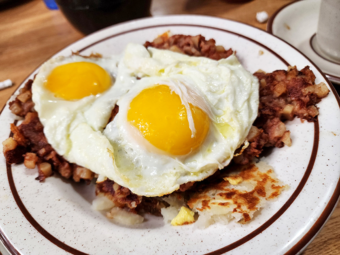 Breakfast perfection: sunny-side up eggs crowning a throne of crispy corned beef hash&mdash;the morning royalty that rules the day.