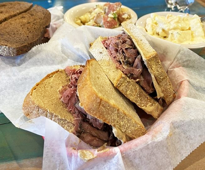 Layers of thinly-sliced corned beef nestled between dark pumpernickel&mdash;a flavor skyscraper that laughs at your attempt to open wide enough.