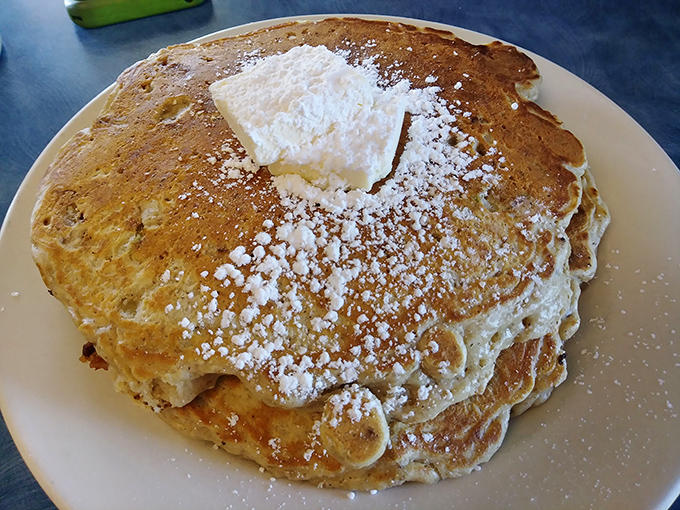 These pancakes aren't just golden brown&mdash;they're wearing powdered sugar like a dusting of fresh snow, with butter melting into that perfect pancake pocket.