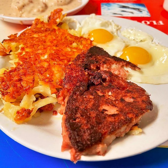 The holy trinity of breakfast: perfectly seared corned beef hash, sunny-side-up eggs with vibrant yolks, and hashbrowns crisped to golden perfection.