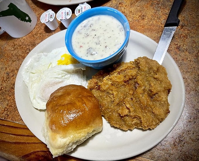 Country fried steak: where crispy exterior meets tender interior in a marriage officiated by gravy. The biscuit is just there to witness the delicious union.