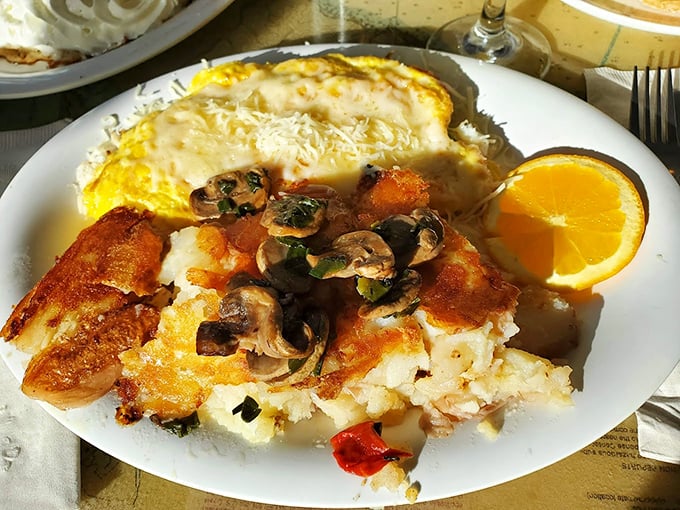 Breakfast alchemy at its finest: fluffy eggs cradling mushrooms and vegetables, with crispy potatoes that deserve their own fan club.