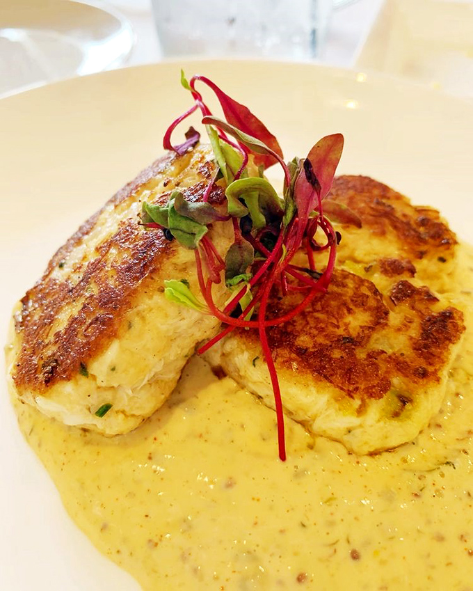 The legendary crab cake&mdash;more crab than cake&mdash;sits regally atop fresh asparagus, proof that sometimes the simplest preparations create the most profound flavors.