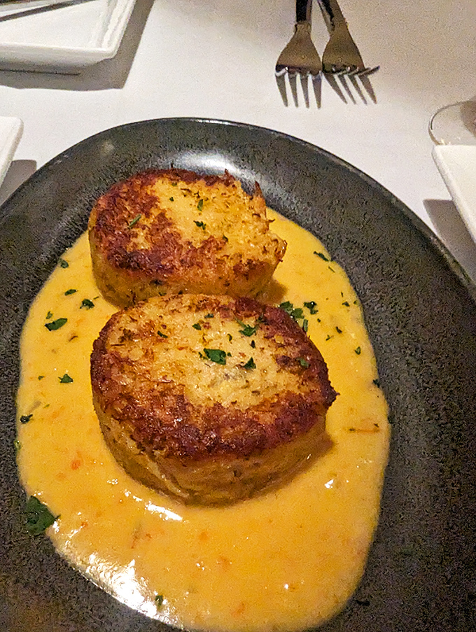 These golden crab cakes swimming in sunshine-colored sauce aren't just appetizers&mdash;they're the opening act that threatens to upstage the headliner.