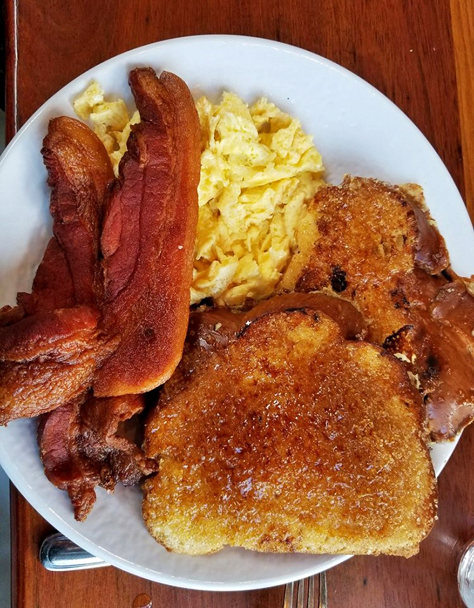 The legendary Cr&egrave;me Brulee French Toast in its natural habitat. That caramelized top shatters like your willpower when the server walks by.