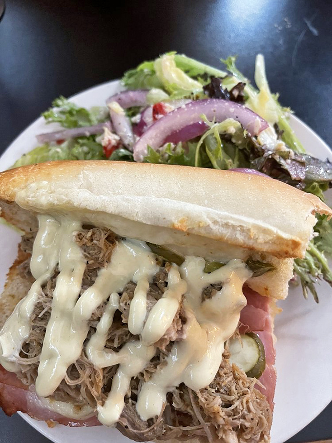 This isn't just a sandwich; it's an architectural marvel of pulled pork, ham, and melty cheese that would make Ernest Hemingway pause mid-sentence in Havana.