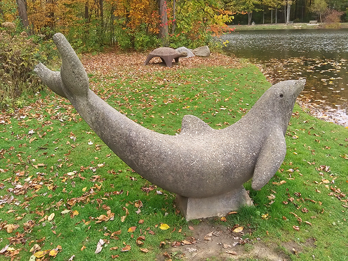 Stone sea creatures, miles from the ocean! This whimsical dolphin sculpture adds unexpected charm to the lakeside landscape, like finding an old friend in a surprising place.