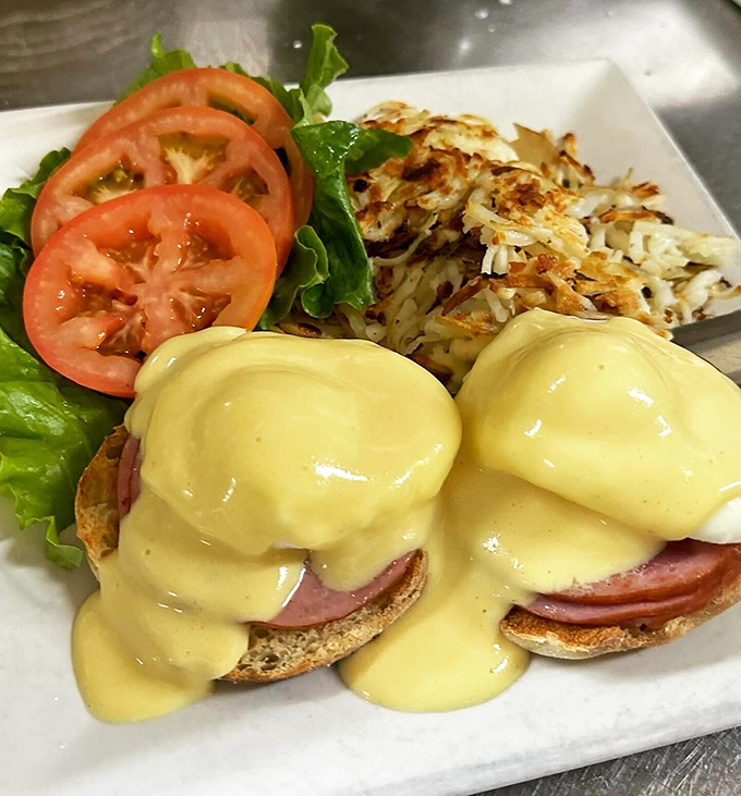 Eggs Benedict done right: poached eggs perched atop Canadian bacon, draped in hollandaise that cascades like a golden waterfall.
