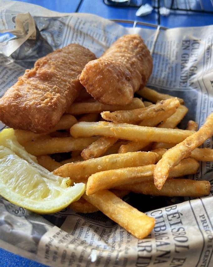 Fish and chips done right - crispy armor protecting flaky treasure, with fries standing guard like delicious soldiers.