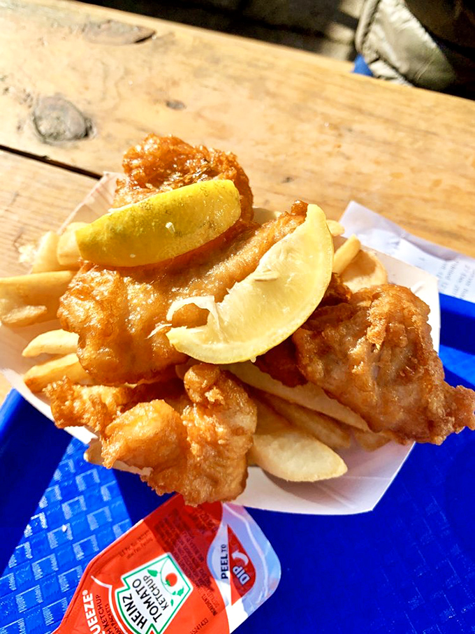 Fish and chips with lemon wedges standing by like faithful sidekicks, ready to add that perfect citrus zing to gloriously crispy bites.