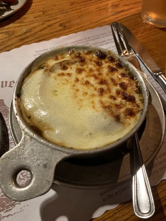 The French onion soup arrives bubbling hot, its crown of golden, crusty cheese concealing a rich broth below. Spoon-breaking satisfaction guaranteed.