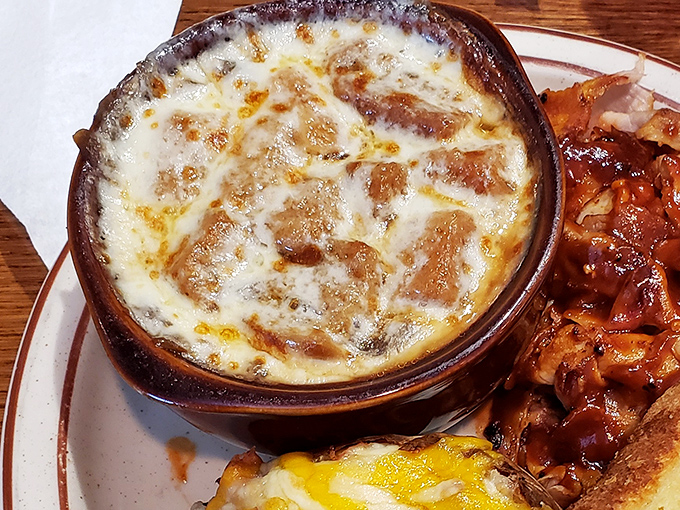 Beneath that golden-brown cheese canopy lies a rich, savory broth &ndash; French onion soup that would make Parisian chefs nod in approval.