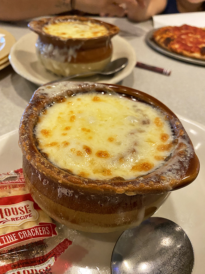 French onion soup that's practically wearing a tuxedo—bubbling cheese canopy over a rich, savory broth that demands a moment of silence.