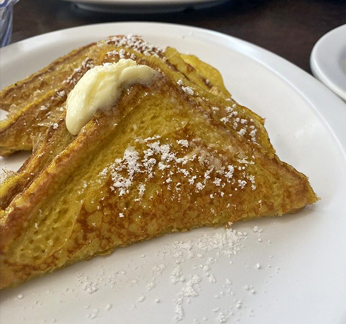 French toast that achieves the impossible trifecta: crisp edges, custardy center, and just enough powdered sugar to make you feel like you're getting away with something.