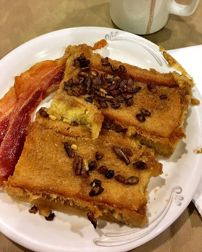 French toast that's had a pecan-studded makeover, flanked by bacon so crisp it practically salutes when you pick it up.