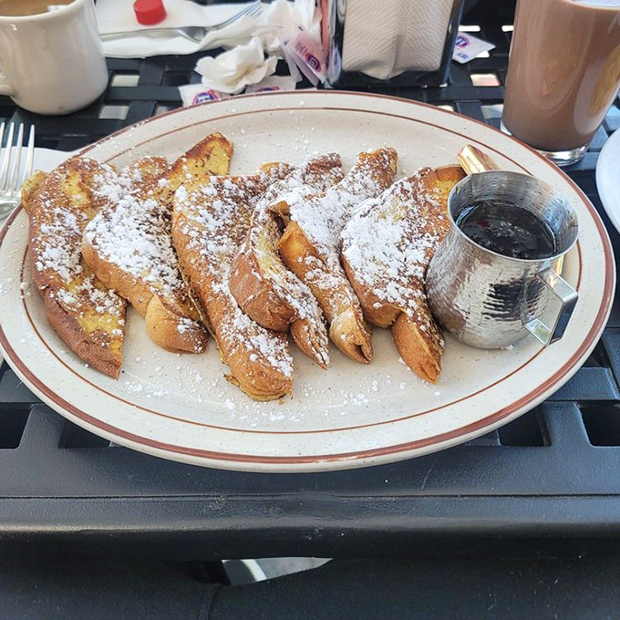 French toast that would make actual French people jealous. Golden, crisp-edged slices dusted with sugar and served with maple syrup in a metal pitcher&mdash;pure morning luxury.
