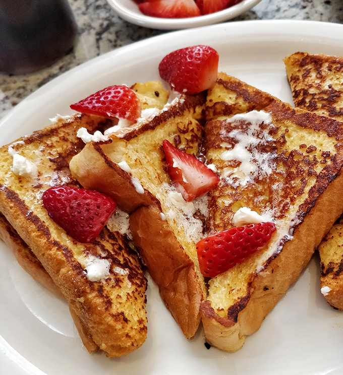 French toast that's dressed for success with fresh strawberries and a dusting of powdered sugar &ndash; breakfast or dessert? Why choose?