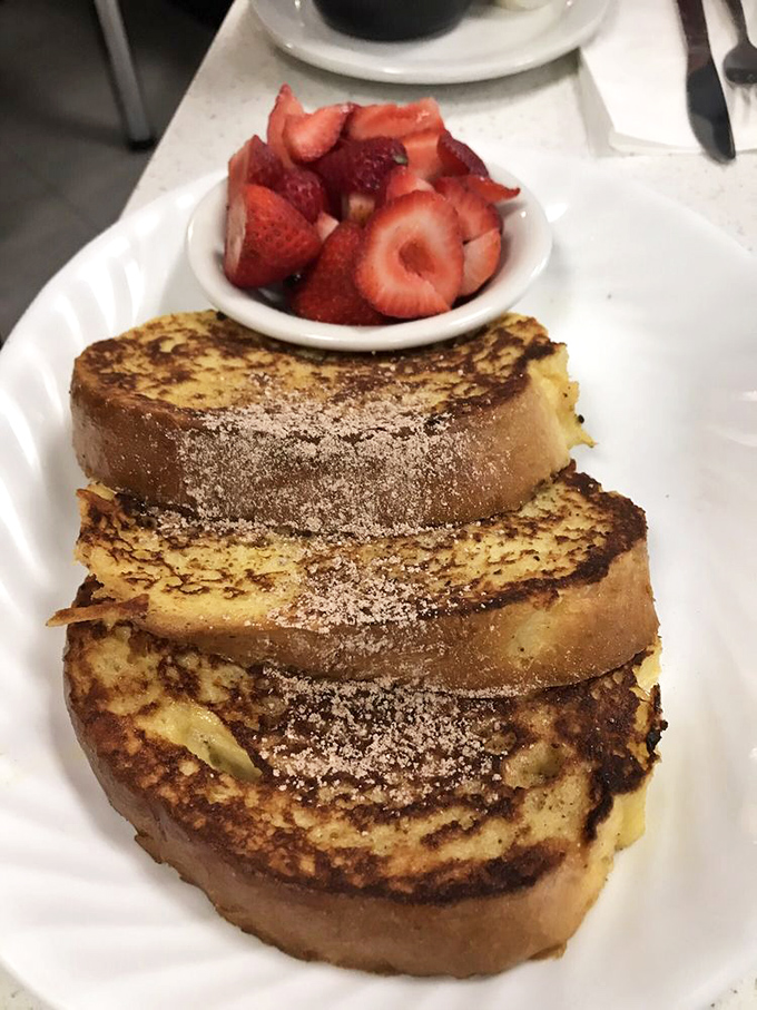 French toast that's had the full spa treatment &ndash; golden-brown, dusted with powdered sugar, and accompanied by fresh strawberries.