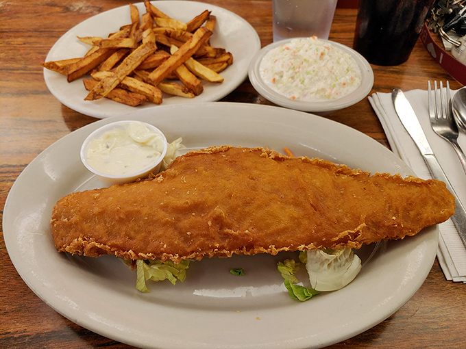 The fried haddock stretches beyond its plate boundaries, golden-brown and glorious. This isn't "fish and chips"&mdash;it's an edible monument to seafood.