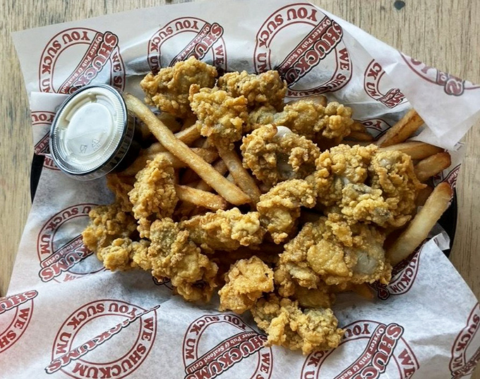 Perfectly golden fried oysters and fries nestled together on branded paper &ndash; proof that sometimes the simplest presentations deliver the most satisfaction.