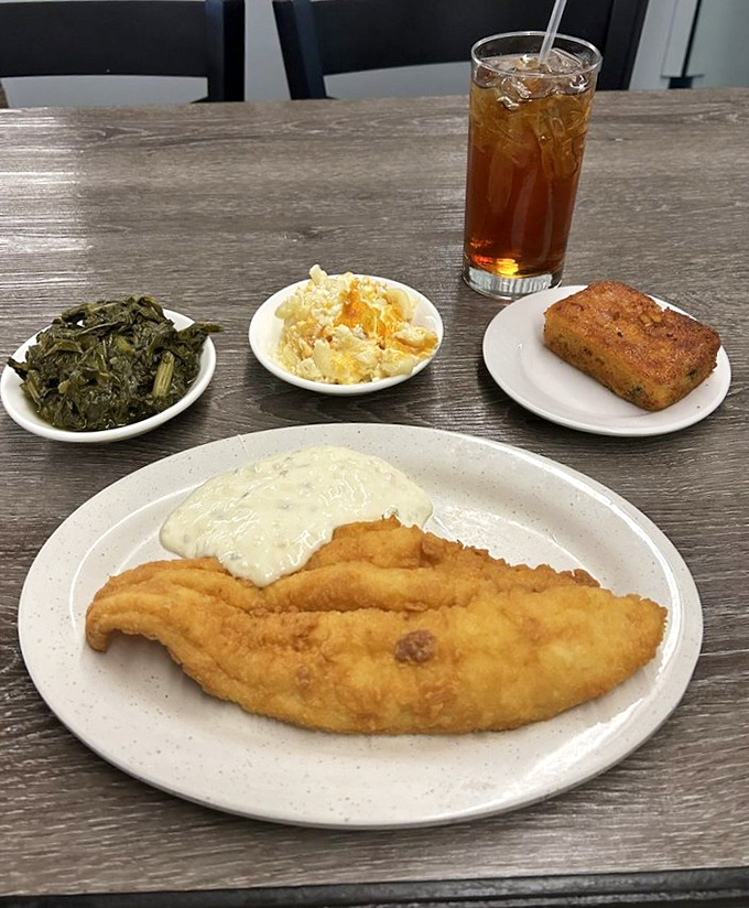 This fried catfish, golden and crisp, lounging beside collards and mac and cheese, is the aquatic equivalent of winning the lottery.