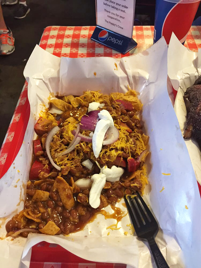 Frito pie elevated to art form: crispy corn chips swimming beneath a blanket of savory meat, cheese, and onions. Comfort food that hugs your soul.