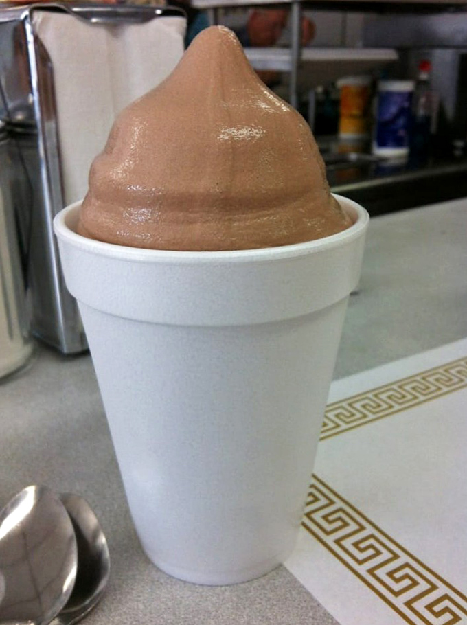 The chocolate malt stands tall like a creamy monument to simpler times. One spoonful and suddenly you're eight years old again, without the homework.