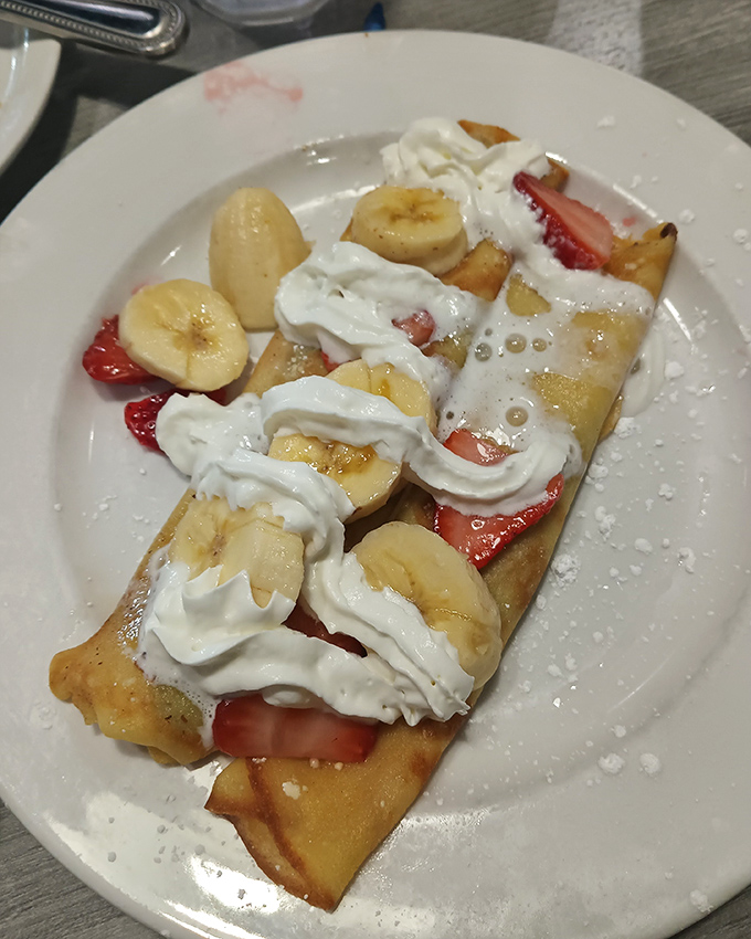 Fresh fruit crepes arrive like edible artwork, proving that healthy and indulgent can dance together beautifully.