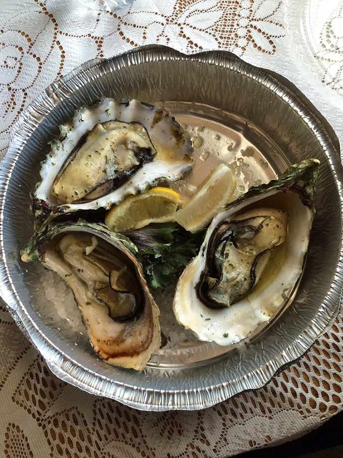 Oysters bathed in buttery goodness, waiting for their lemon squeeze. Nature's perfect appetizer, improved only by fire and garlic.