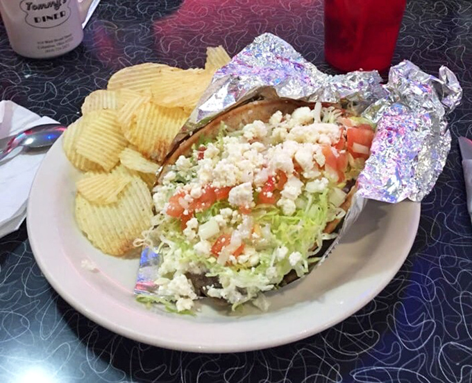 This gyro isn't just a sandwich, it's an edible work of art—fresh veggies, feta crumbles, and seasoned meat nestled in foil like a present.