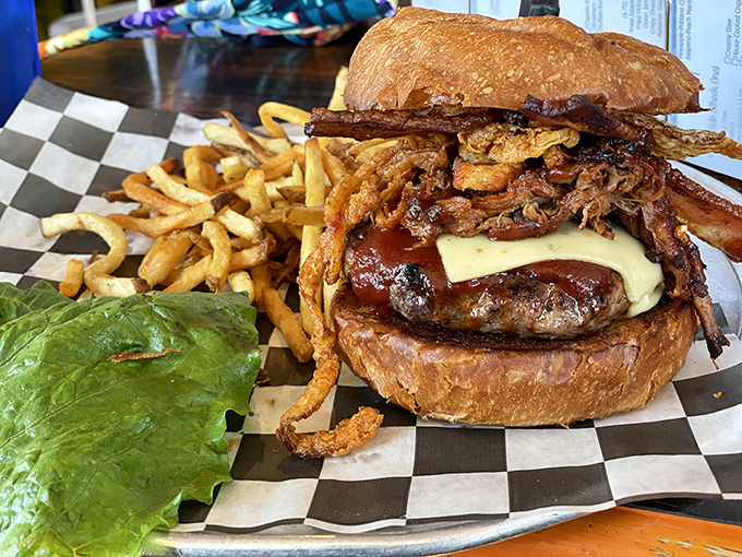 A burger so tall it needs its own zip code, flanked by fries that look hand-cut by someone who really, really cares about potatoes.