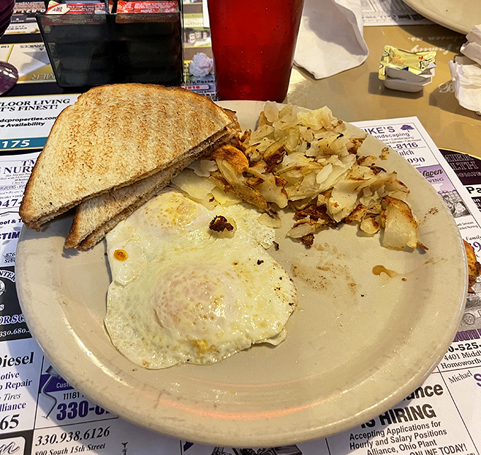 The breakfast trinity: eggs with edges perfectly laced, potatoes with the ideal crisp-to-tender ratio, and toast standing by for important yolk-sopping duties.