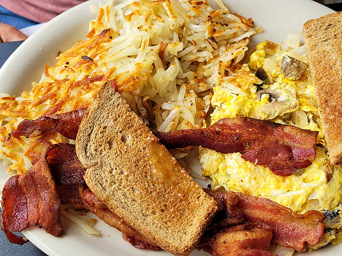 Breakfast alchemy: crispy-edged hash browns, eggs with sunshine-yellow yolks, and bacon that's achieved the perfect balance between chewy and crisp.