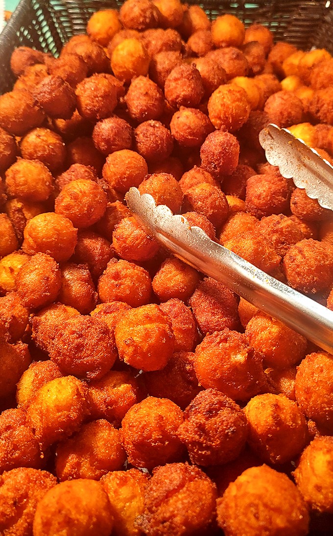 These hush puppies aren't telling tales, but they're speaking volumes about perfect frying technique. Golden, crispy orbs of cornmeal joy!